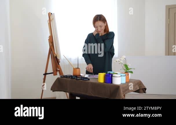 woman artist, preparing a palette of colors for painting. Gently mixes ...