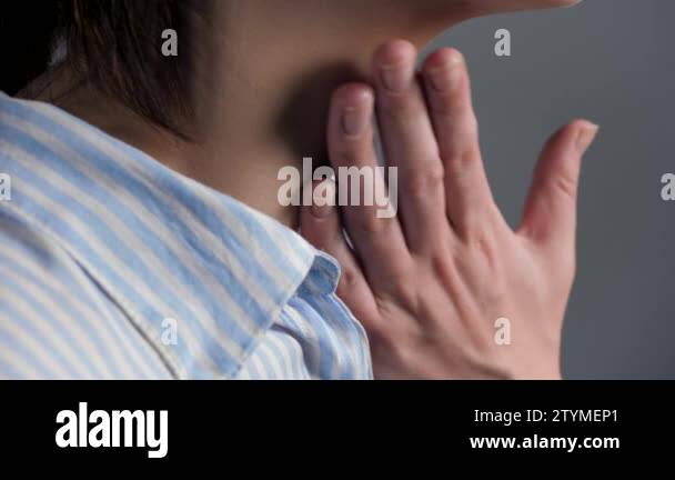 Woman touches her throat her hand and swallows. Sore throat ...