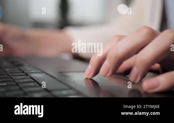 Left female hand moves finger across laptop touchpad and presses right ...