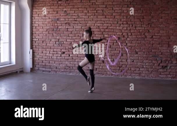 Rhythmic gymnastics: Girl in black body perform gymnastics exercise ...