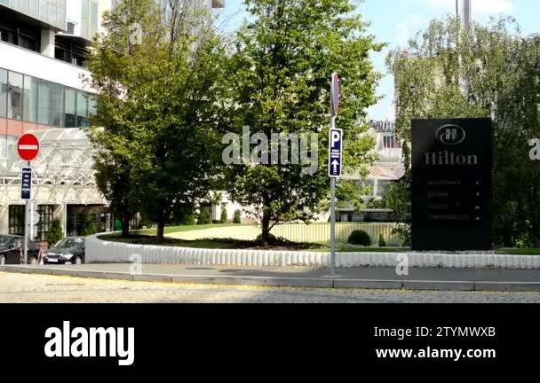 Hilton modern hotel - exterior - symbol (sign) - trees and cars - sunny ...