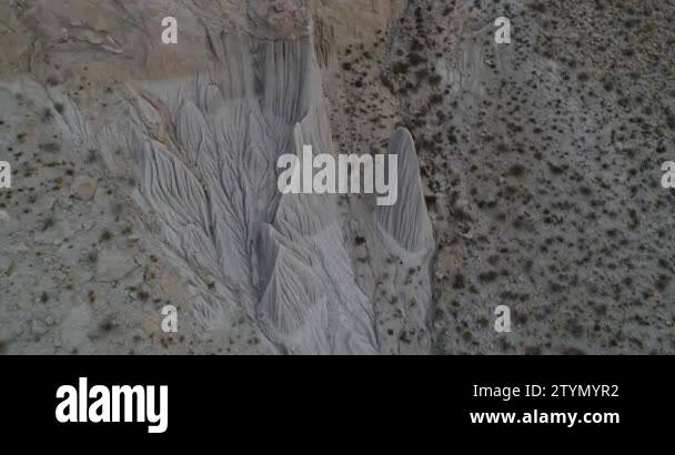 Flying towards eroded mountain slope from general to senital detail of ...