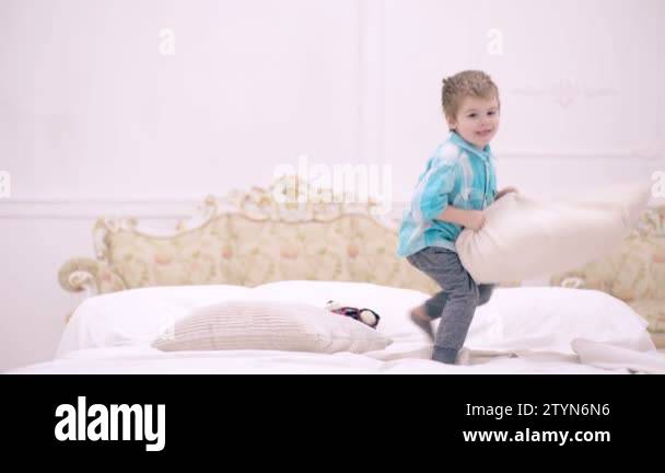 Little child playing in bed, home leisure. Happy boy jumping on the bed ...