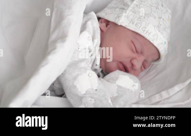 Close-up of a newborn baby through sleep facial expressions ...
