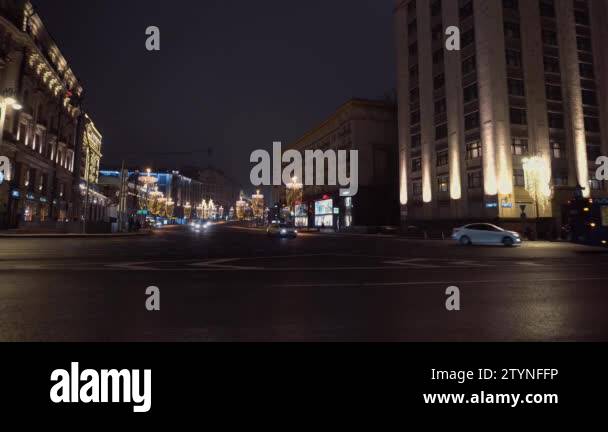 Crossroads of night city. Majestic architecture, cars drive from left ...