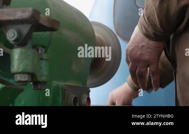 Hands old master grind detail on bench grinder, rough grinding machine ...