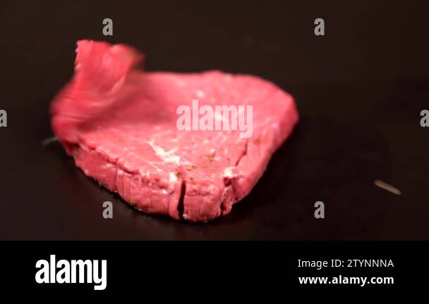 Slab of tender lean raw steak falling onto black Stock Video Footage ...