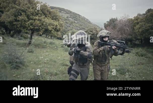 Squad of fully armed commando soldiers during combat in a forest ...