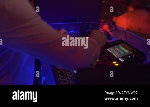 Dj playing music on mixing console in colorful light in nightclub. DJ ...