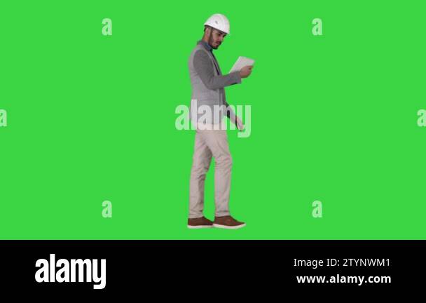 Engineer walking and working on digital tablet on a Green Screen ...