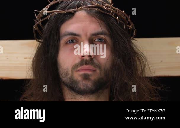 Crying Jesus Christ in crown of thorns looking at camera, crucifixion on cross Stock Video ...