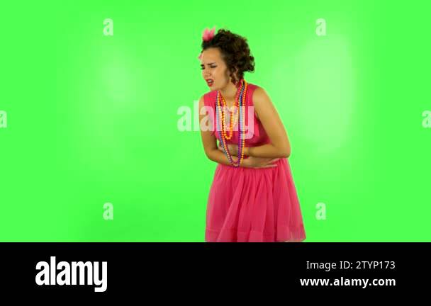 Cute female feels very bad, her stomach hurts against green screen at ...