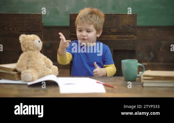 Little boy counting on fingers with green chalkboard background. Back ...