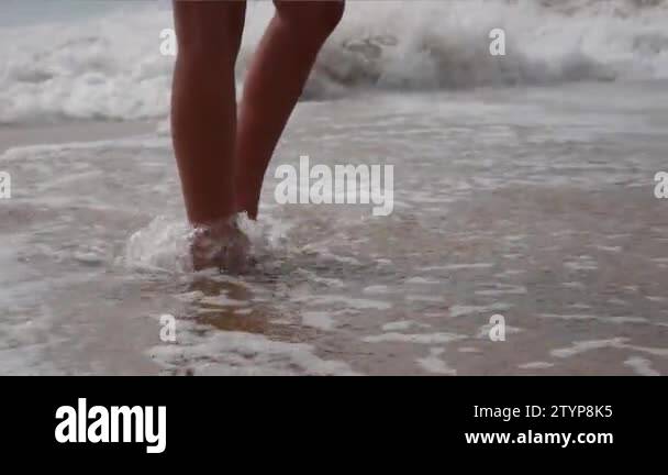 Woman bare foot walking on the summer beach. close up leg of young ...