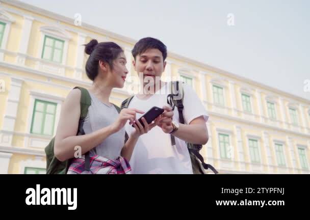 Traveler Asian couple direction on location map in Bangkok, Thailand, couple using mobile phone ...