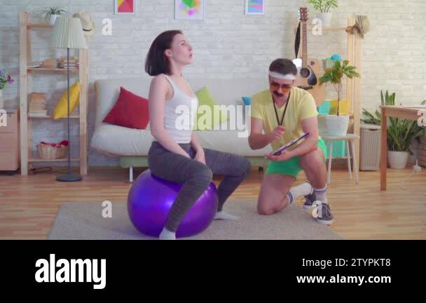 Funny coach man with a mustache from the 80s trains a girl on a fitness ...