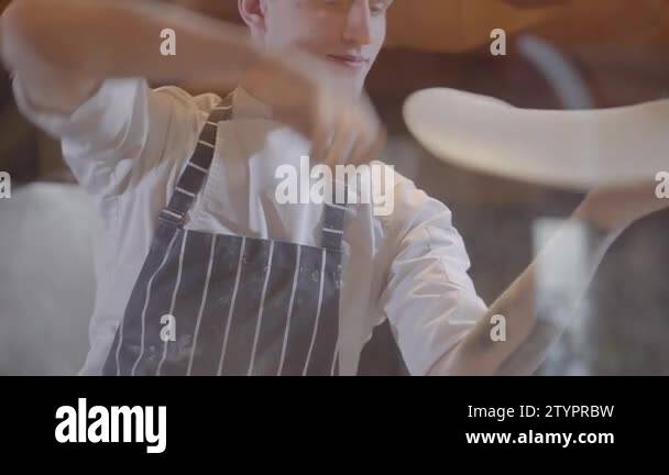 Skillful positive pizza maker is cooking dough at modern restaurant ...