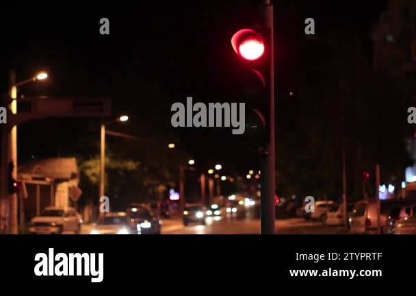 Traffic at night stopping at a stop light waiting for it to turn green ...