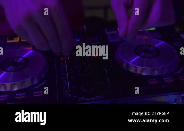 Male hand disk jockey on mixing console for mixing techo music on disco ...