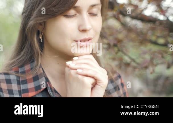 young woman moves lips saying the words of the prayer to God , girl ...