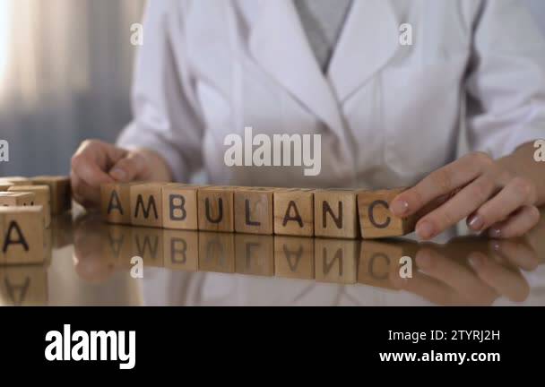 Female doctor making word ambulance of wooden cubes, urgent medical ...
