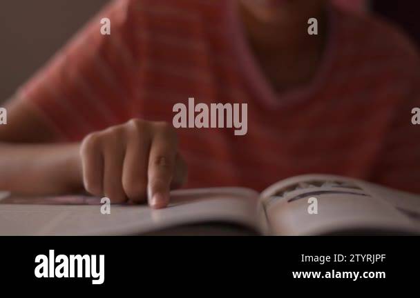 Little girl reading a book. Female student moves her fingers along the ...