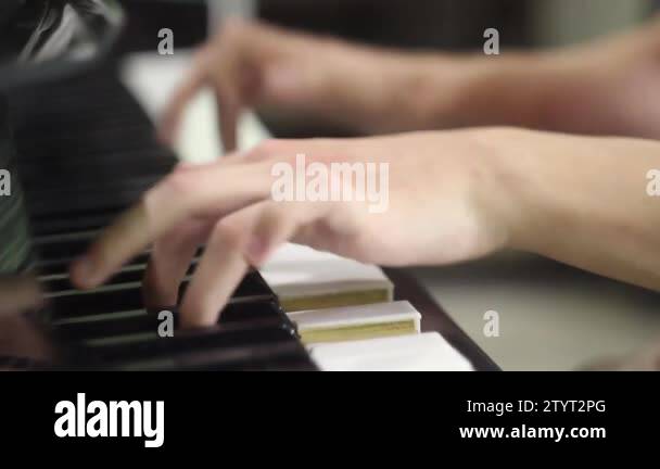 young man playing the piano. hands close up. exercises on the musical ...