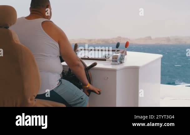 Fat Captain Controls the Tourist Yacht in Sea Storm. Steering Wheel of ...