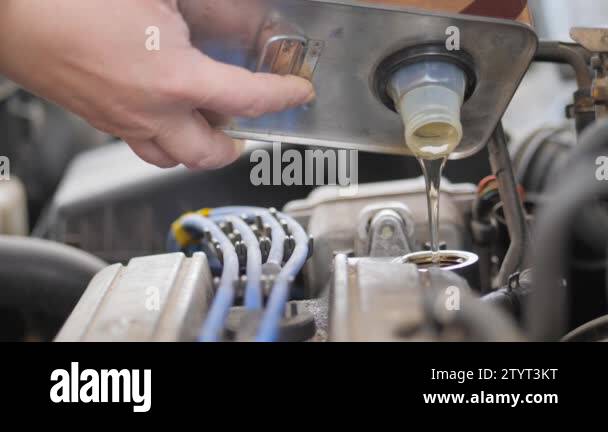 Fill oil in an internal combustion engine. A jet of liquid flows from a ...