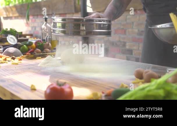 Chef cook pouring flour powder through sieve for kneading dough. Man ...