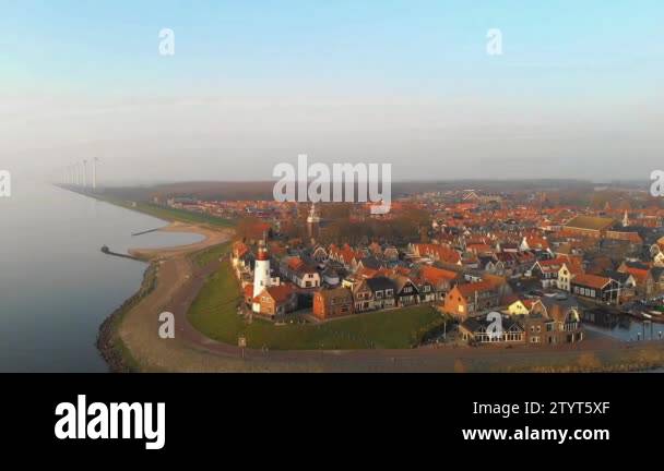 Lighthouse of urk on the rocky beach at the lake Ijsselmeer by the ...