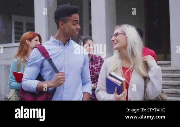 Happy smiling multiethnic friends walking outside college in conversation. Multiethnic group of ...