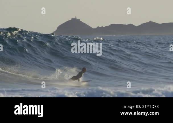 SLOW MOTION: Surfer lying before standing up on his cool surfboard to ...