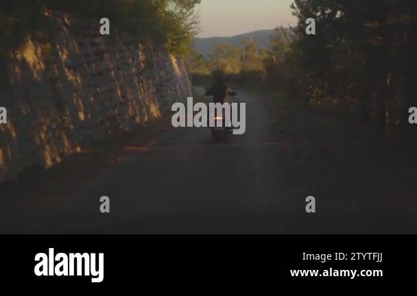 Rear view of a man riding a motorcycle. Stock. Man riding a motorcycle ...