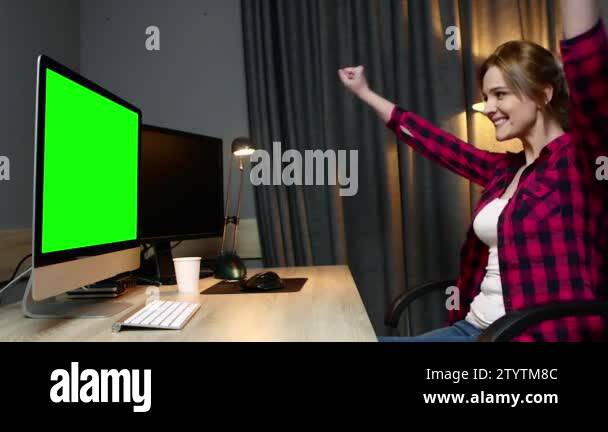 Woman works on her computer, works in office. Monitor green screen ...
