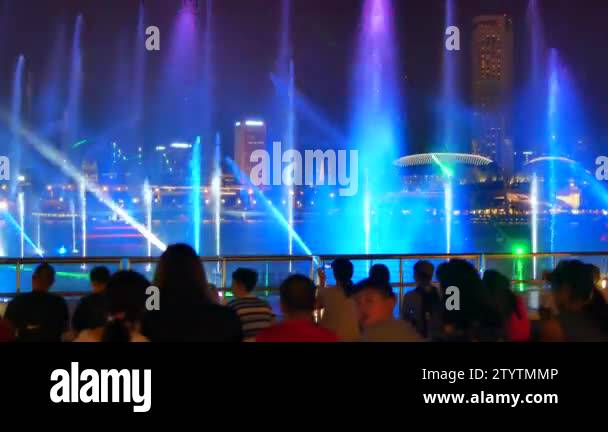 People take pictures of light and water laser show at the Event Plaza ...