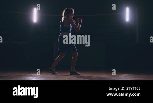 Boxer woman in red bandages on the hands of and blue t-shirt conducts ...
