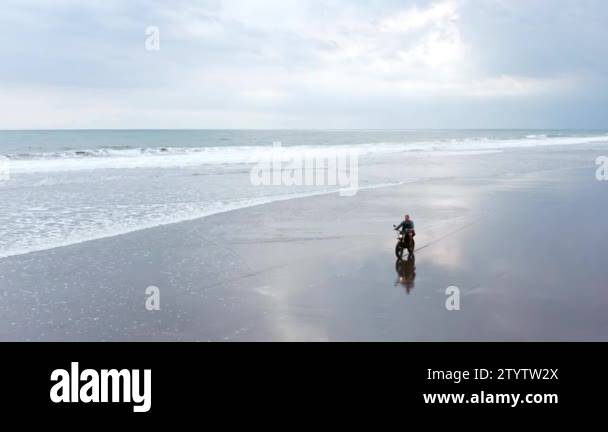 Man in riding motorcycle on beach. vintage motorbike on beach sunset on ...