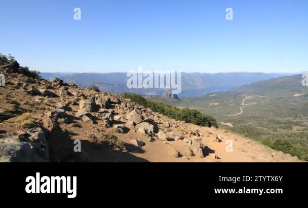 Trekking, going down the mountain summit. Rocky and bare soil trail ...