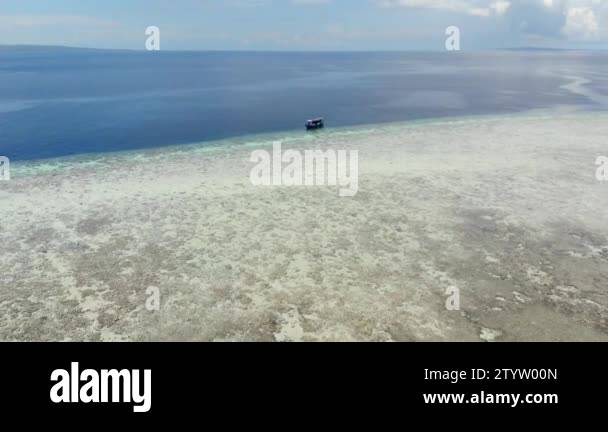 Aerial: Flying over idyllic atoll, travel destination Wakatobi National ...
