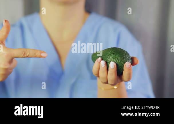 In female hands, the fruit of avocado. A hand is pointing at him Stock ...