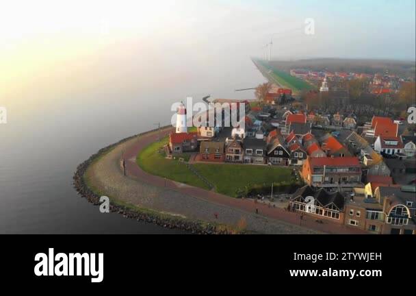 Lighthouse of urk on the rocky beach at the lake Ijsselmeer by the ...