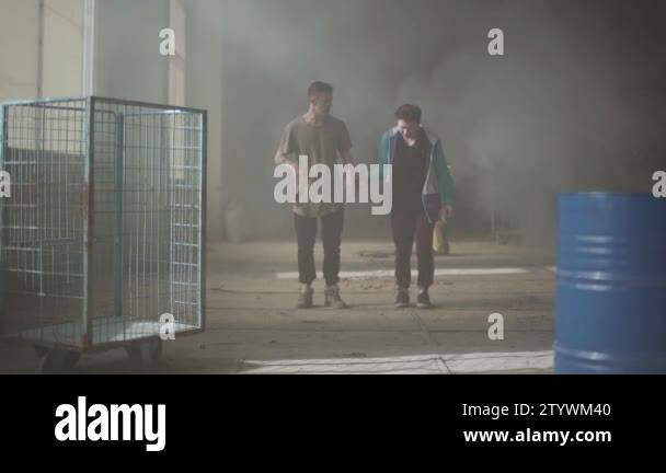 Two men dancing in the dark and dusty room of abandoned building ...