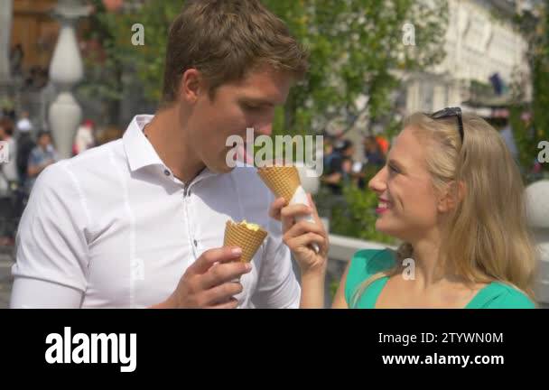 CLOSE UP: Girl offers her ice cream to boyfriend and dips his nose into ...