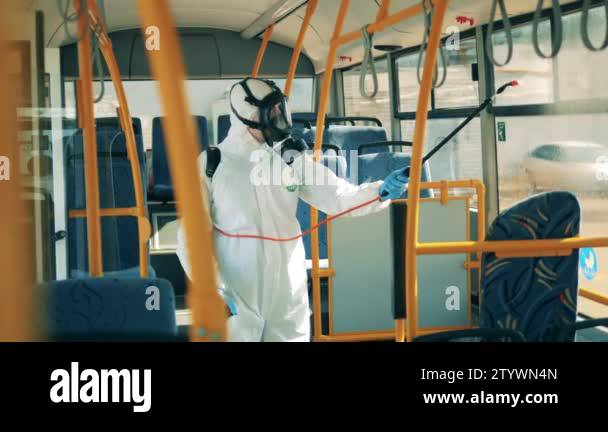 A person in a hazmat suit is disinfecting bus windows. Coronavirus ...