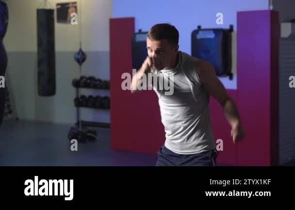 Man boxer training throwing punches at the camera in gym, shadow fight ...