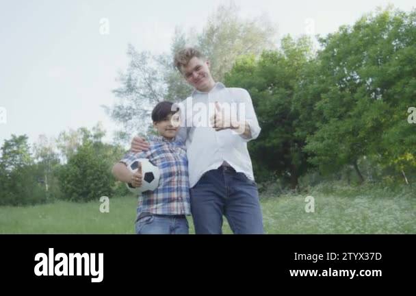 Portrait boy and his dad showing thumbs up. The child holding soccer ...