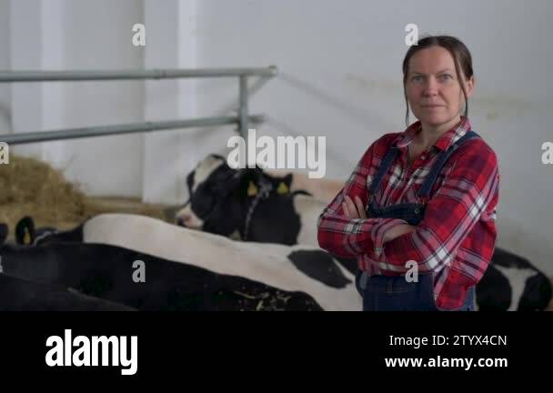 Female farmer in cow shed on a dairy livestock farm, portrait of ...