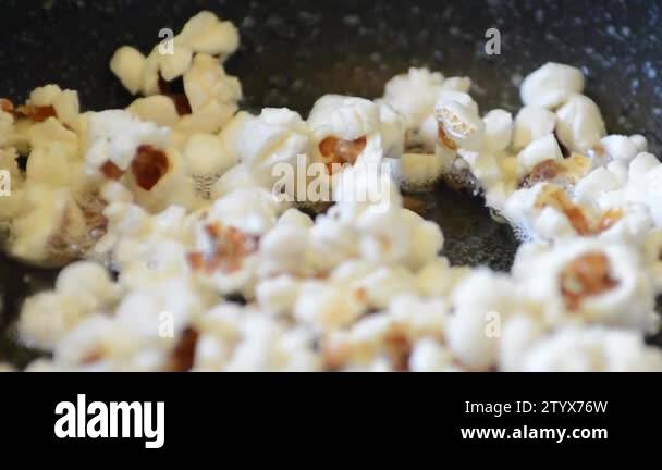 Popcorn is boiled in hot boiling vegetable oil, explodes and shoots up ...