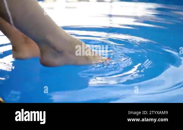 close-up footage of female feet splashing water in swimming pool Stock ...